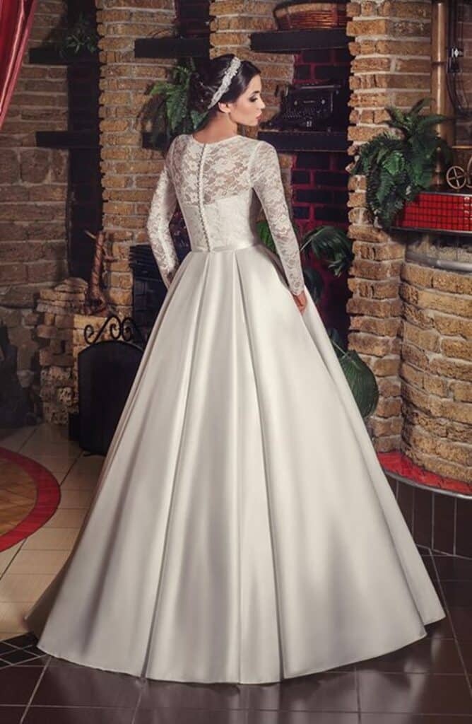 Elegante vestito da sposa invernale fatto in pizzo il corpetto con maniche